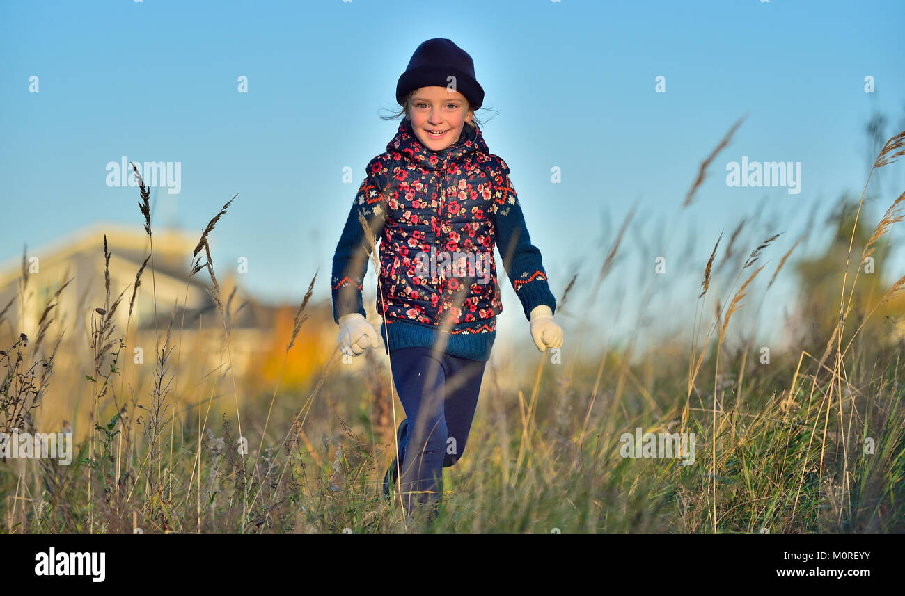 Laughing Happy little girl running in sunlight on autumn meadow Stock ...