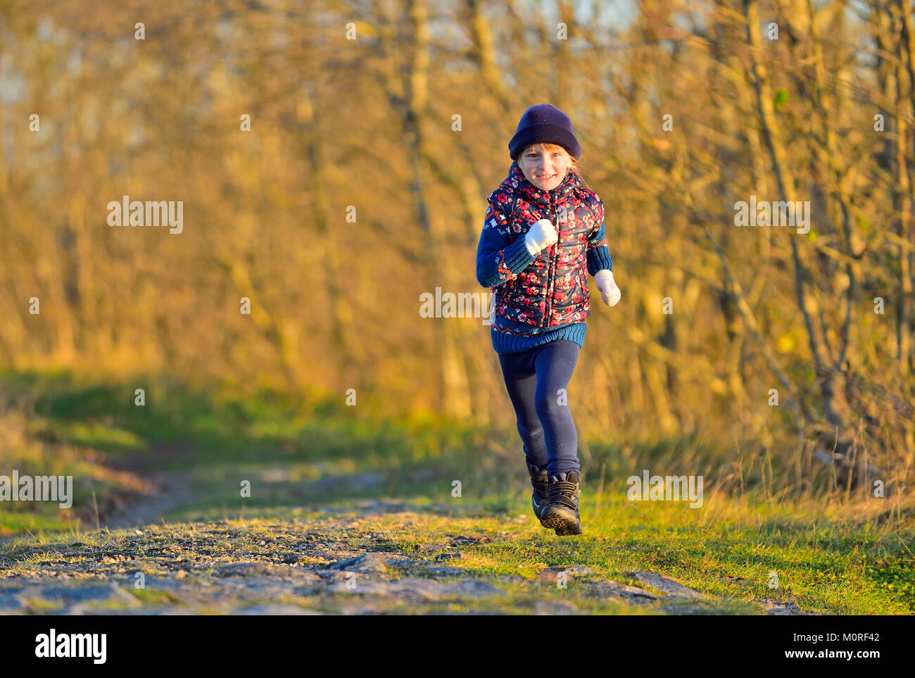 Laughing Happy little girl running in sunlight on autumn meadow Stock ...