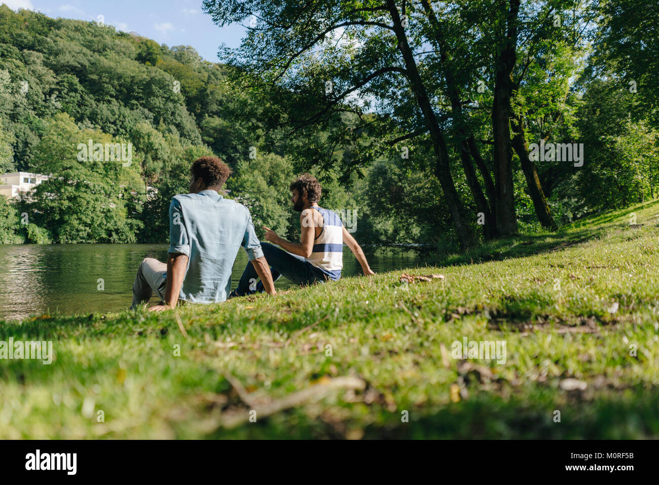 Two friends relaxing at the water Stock Photo - Alamy