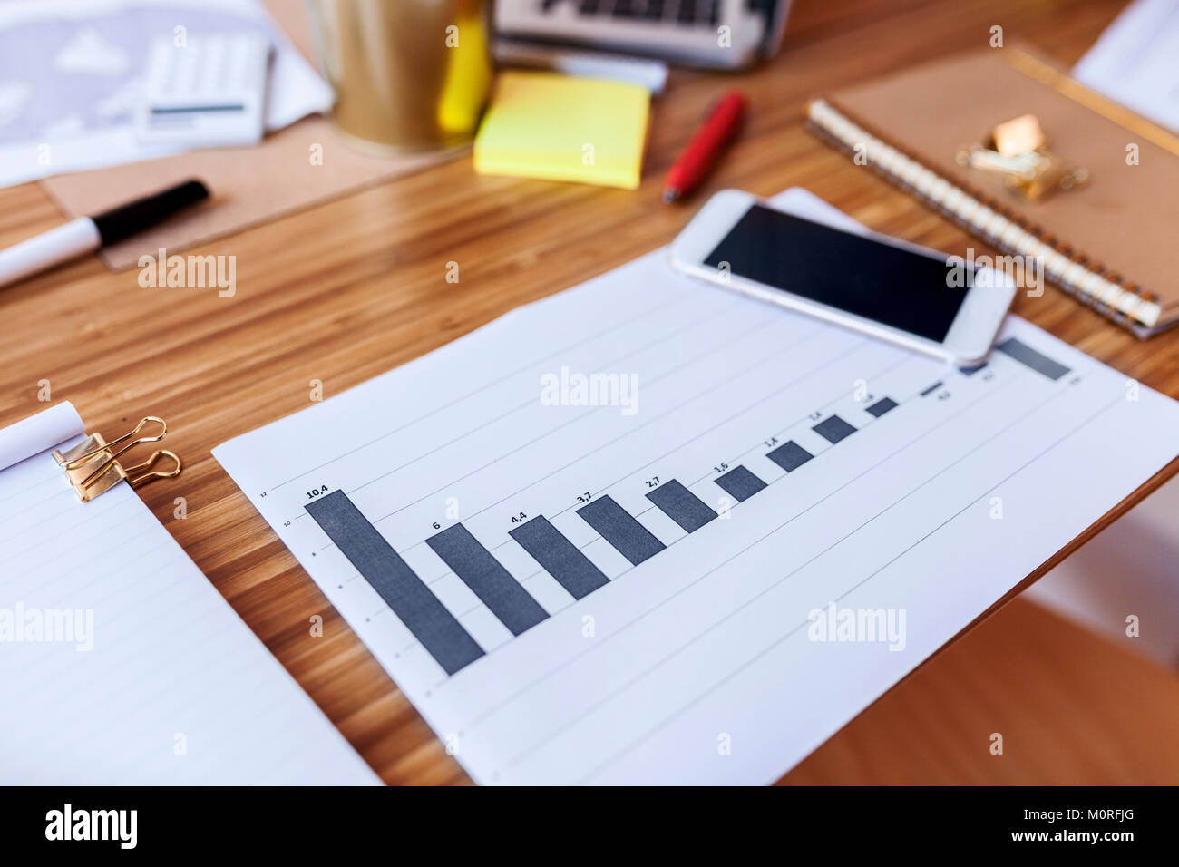Paper with graph on desk in office Stock Photo - Alamy