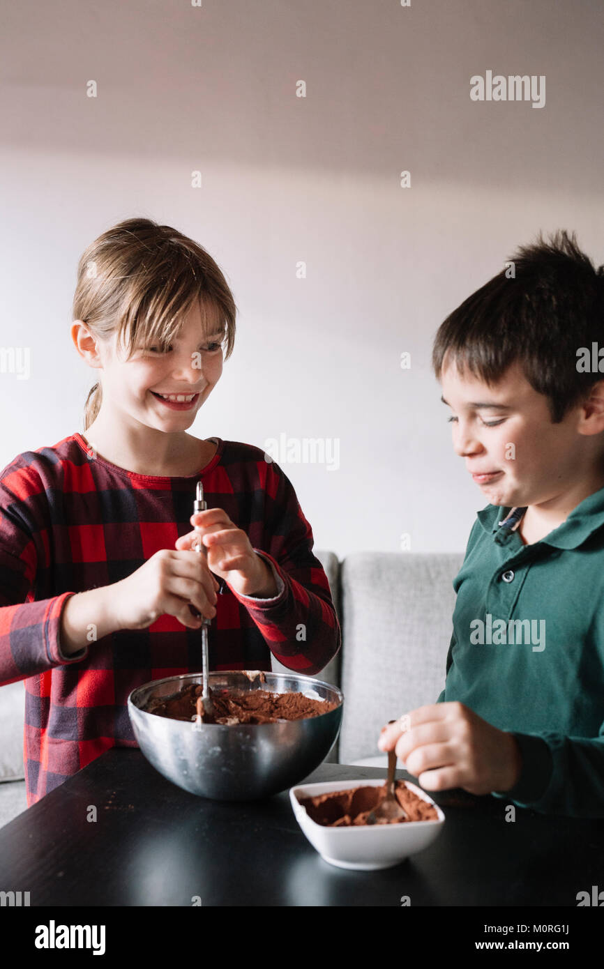 Girl preparing batter while her brother watching Stock Photo - Alamy