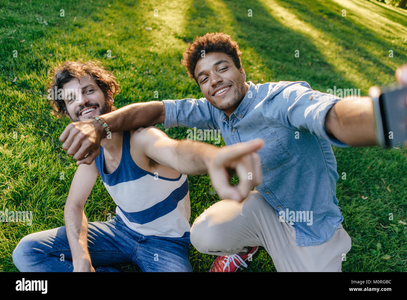 Two happy friends posing for a selfie in a park Stock Photo - Alamy