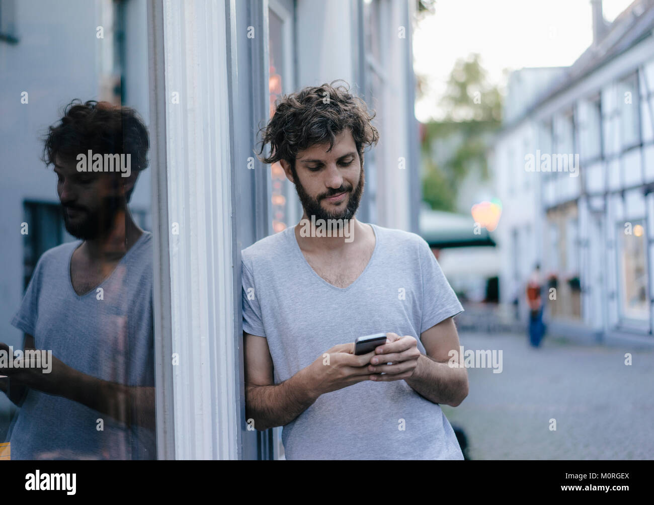 Man looking at cell phone in the city Stock Photo - Alamy