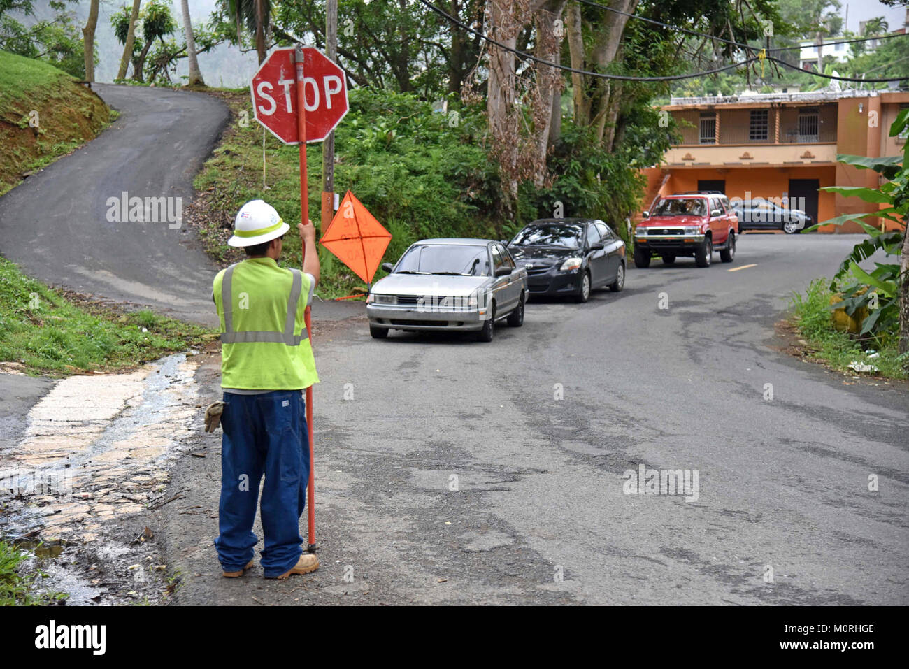 A flagman signals traffic to stop as the approach a crew from Fluor ...