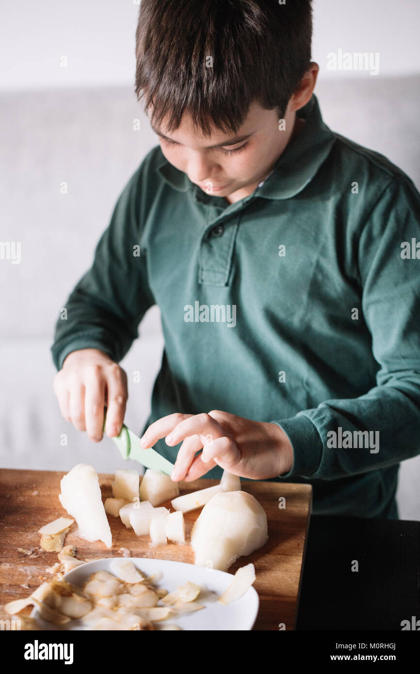 Boy chopping pear Stock Photo - Alamy