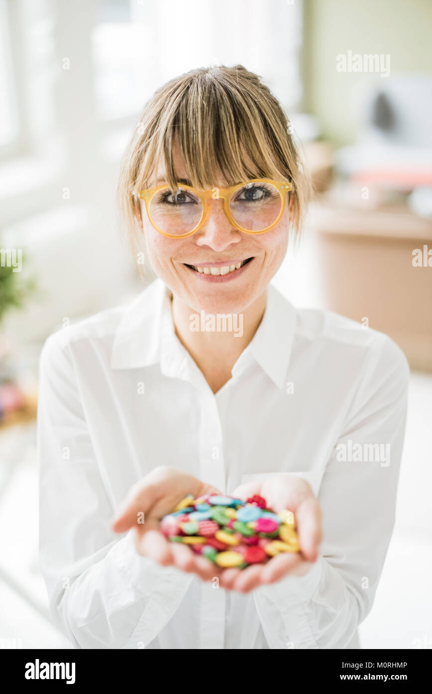 Portrait of smiling woman holding buttons Stock Photo - Alamy