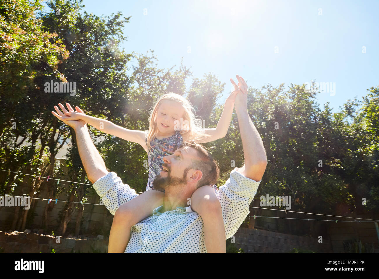 Happy father carrying daughter on shoulders Stock Photo - Alamy