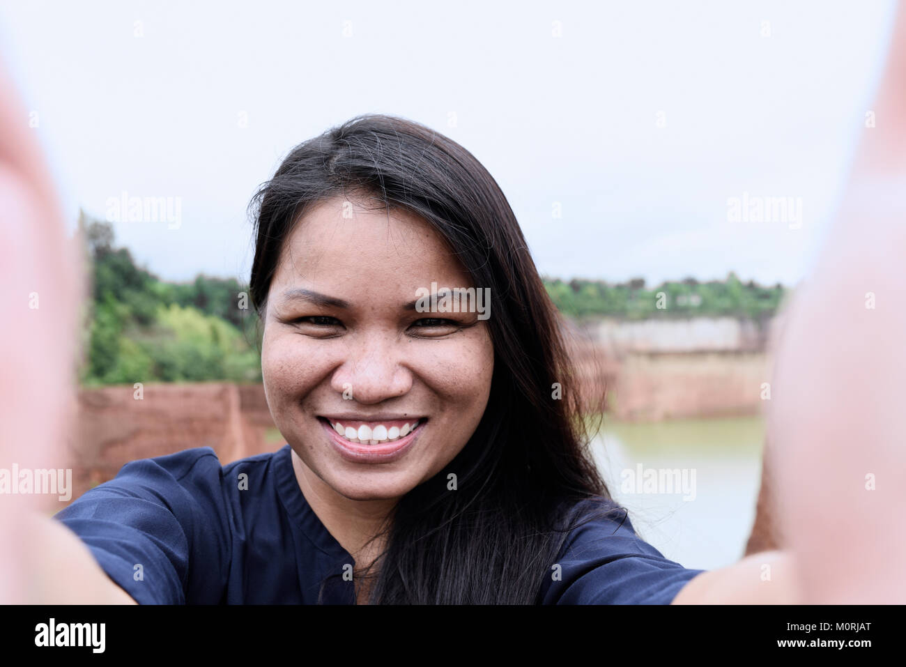 Beautiful Asian Woman Taking A Self Portrait With Her Phone Smiling At