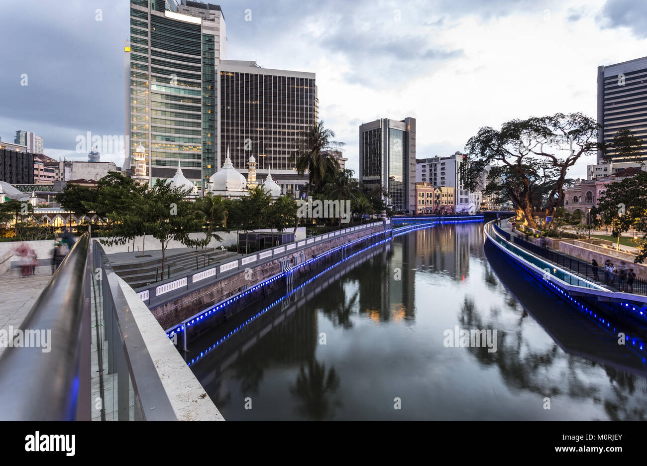 Office buildings reflect in the water of the Klang river in front of ...