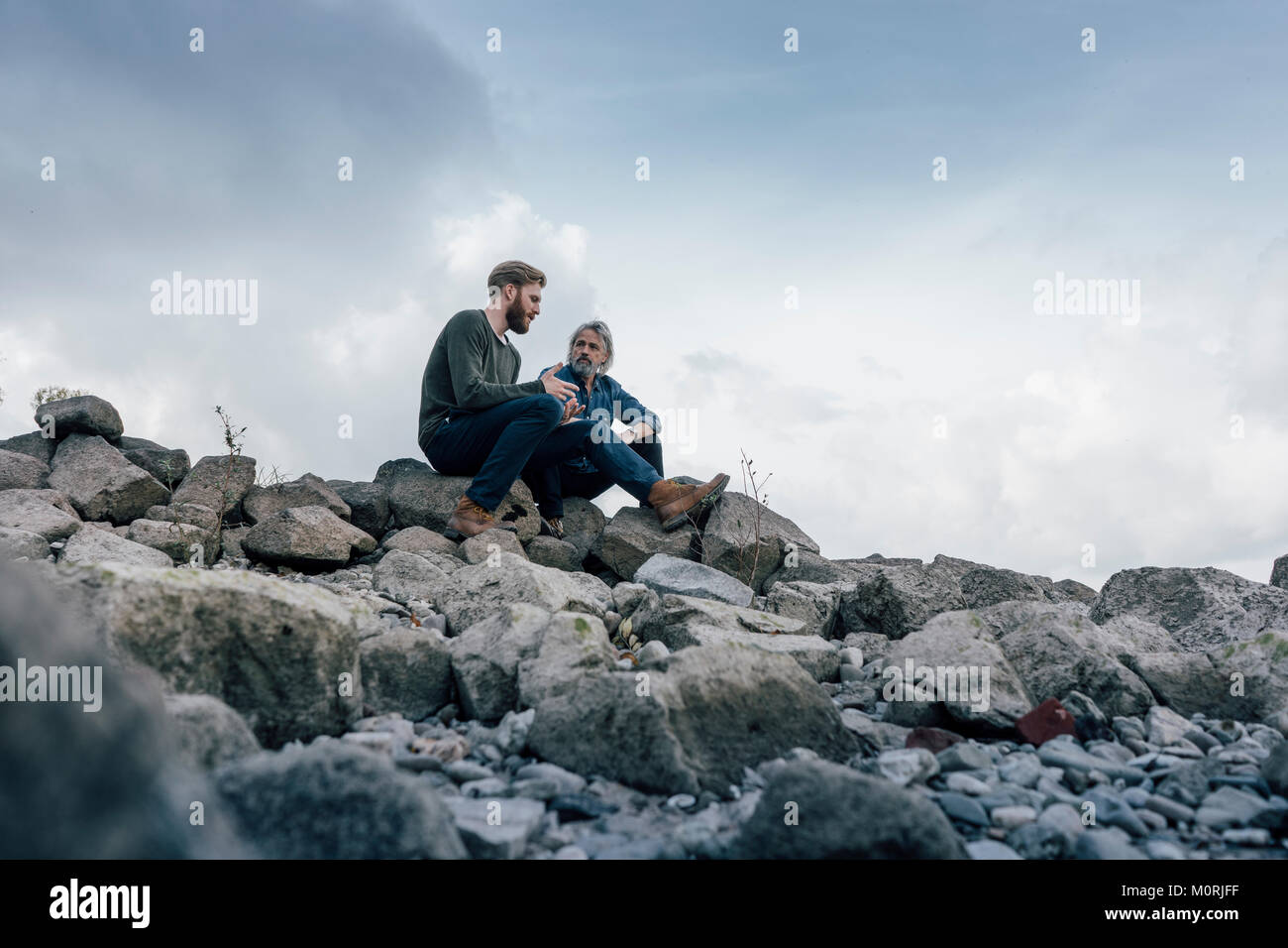 Father and son spending time together outdoors, taking a break, sitting ...