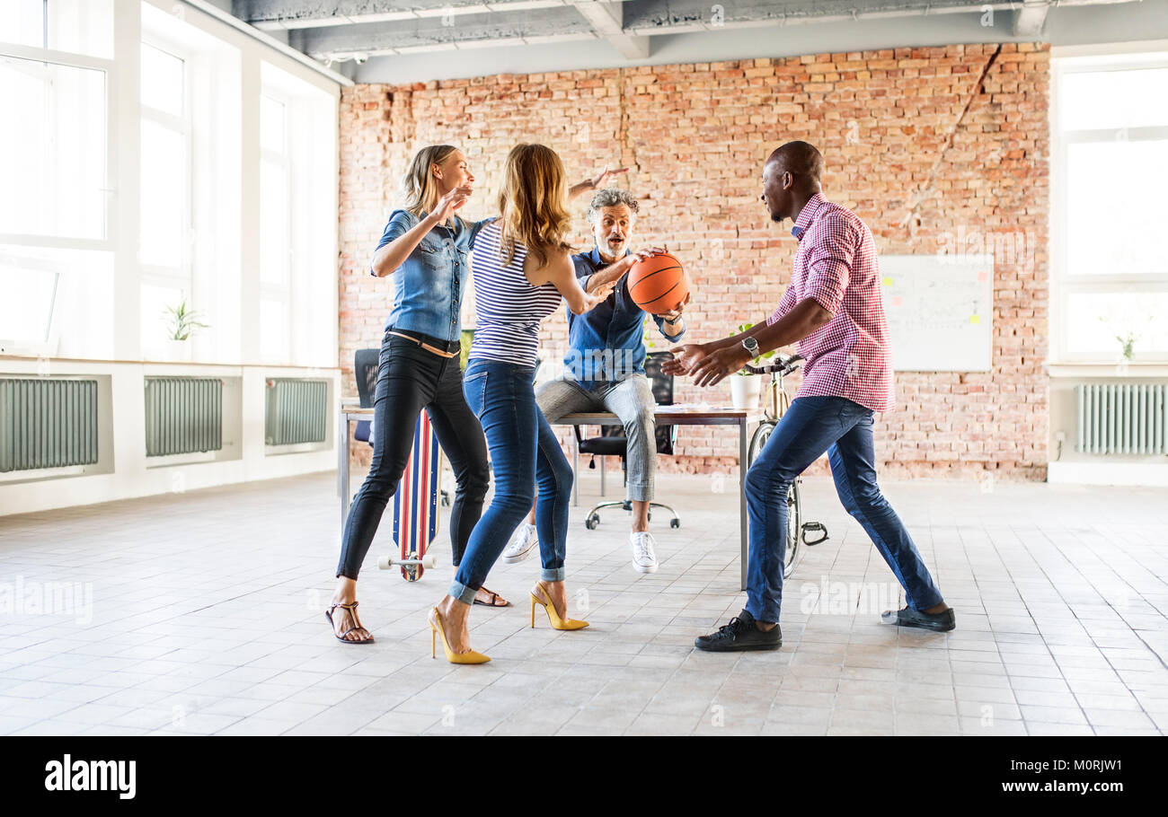 Colleagues playing basketball in office Stock Photo - Alamy