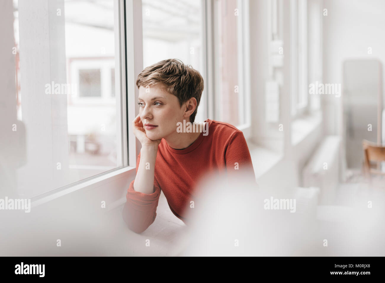 Pensive woman looking out of window Stock Photo - Alamy