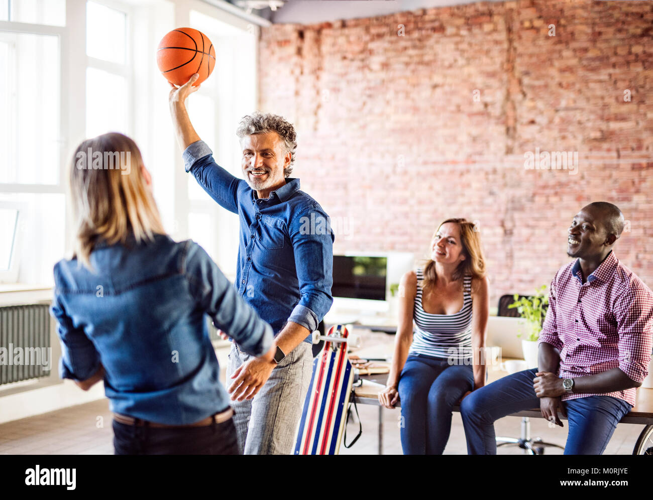 Colleagues playing basketball in office Stock Photo - Alamy