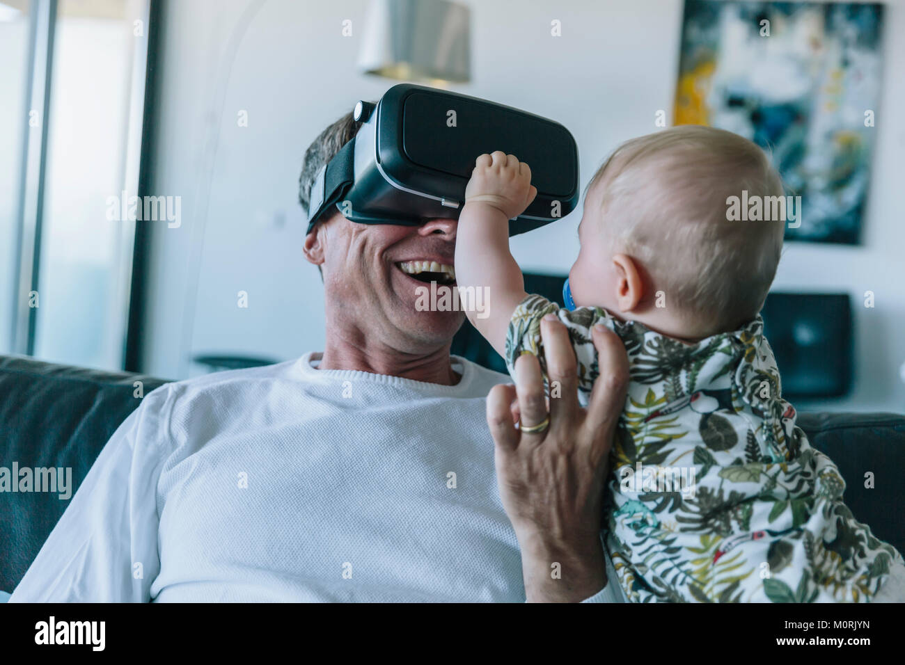 Happy man with baby wearing VR glasses Stock Photo - Alamy