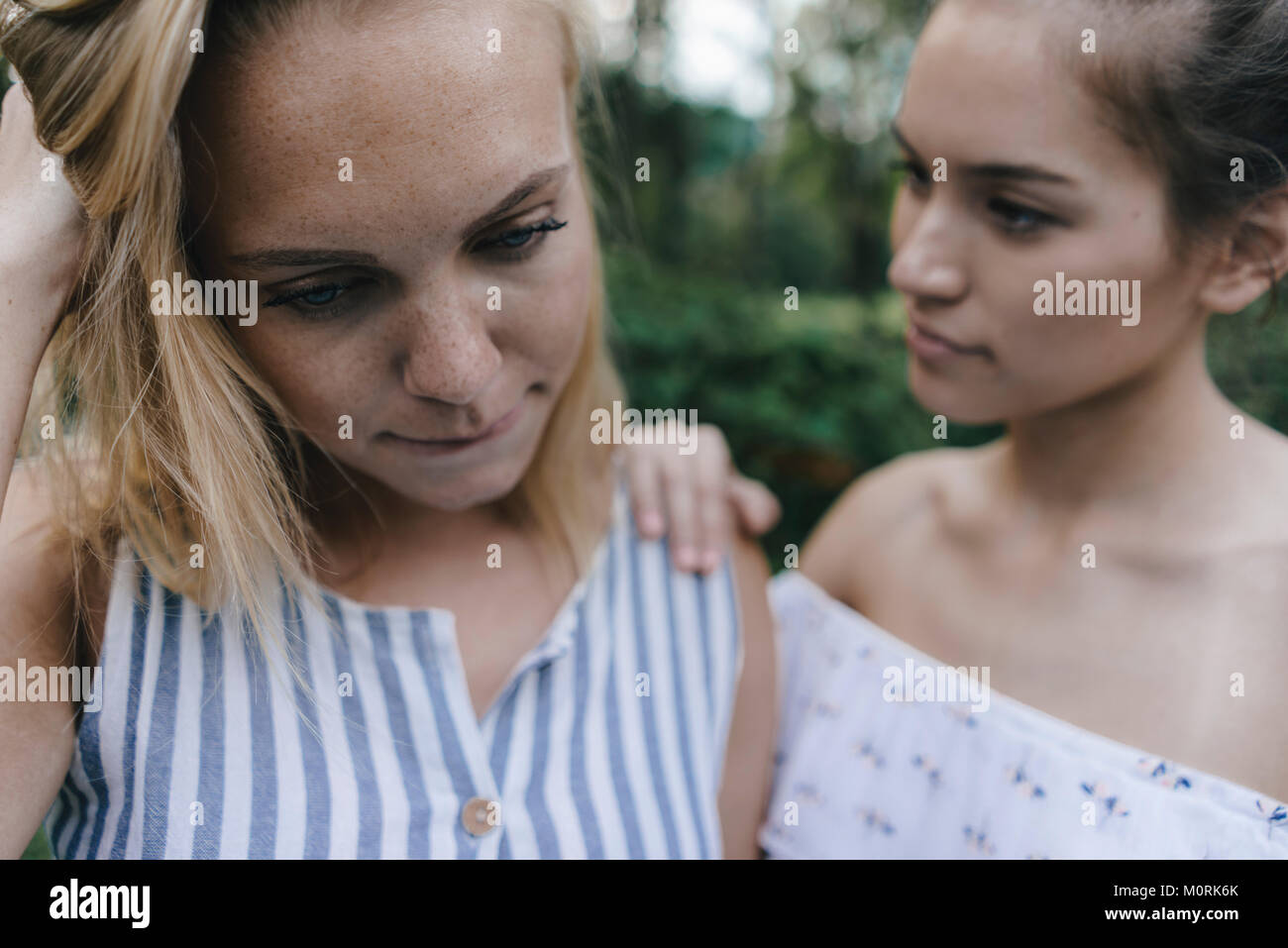 Young woman comforting sad female friend Stock Photo - Alamy