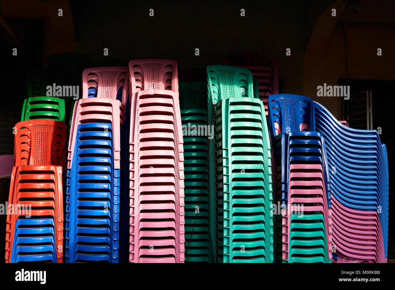 Stacks of coloured plastic chairs Stock Photo - Alamy