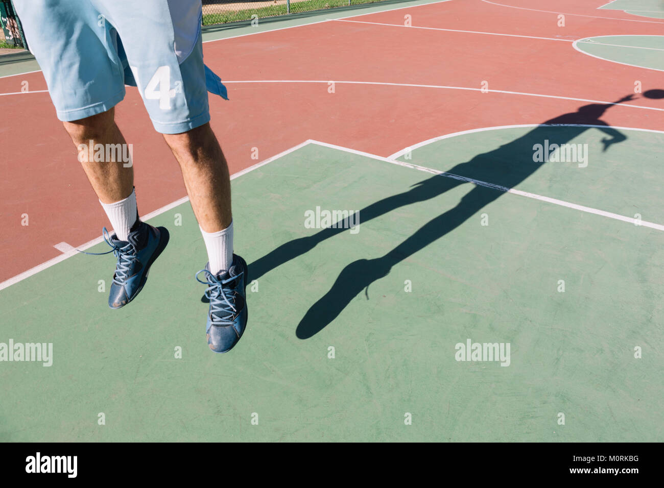 Man playing basketball, jumping, shadow Stock Photo - Alamy