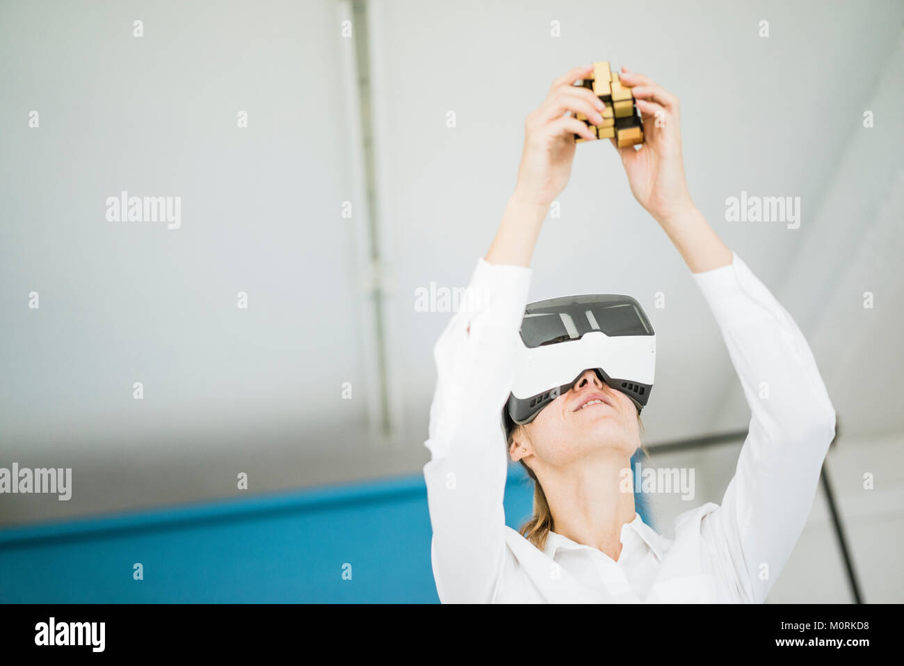 Businesswoman wearing VR glasses holding cubical structure Stock Photo ...