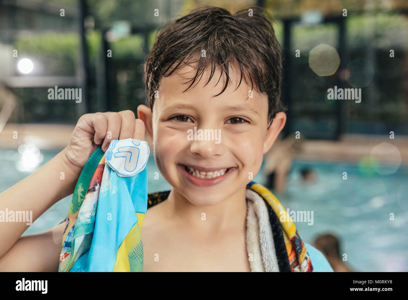 Portrait of proud boy showing his swimming badge at the poolside of an ... Portrait of proud boy showing his swimming badge at the poolside of an ...