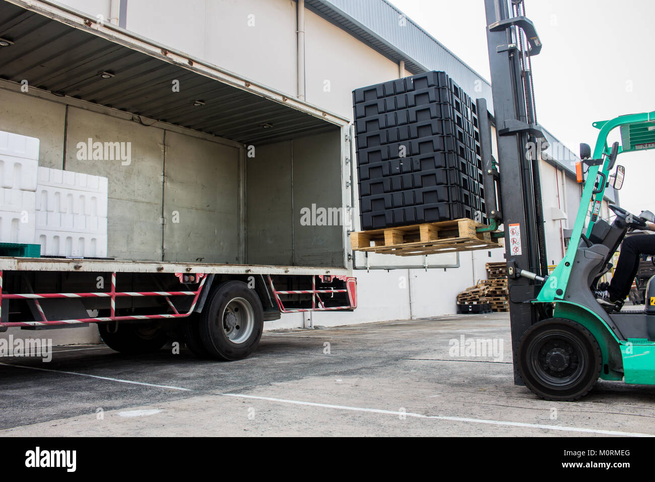 The worker loading pallet with a forklift into a truck Stock Photo - Alamy