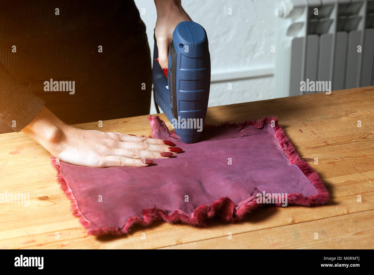The process of making a woman's fur coat. A close-up of a young furrier ...