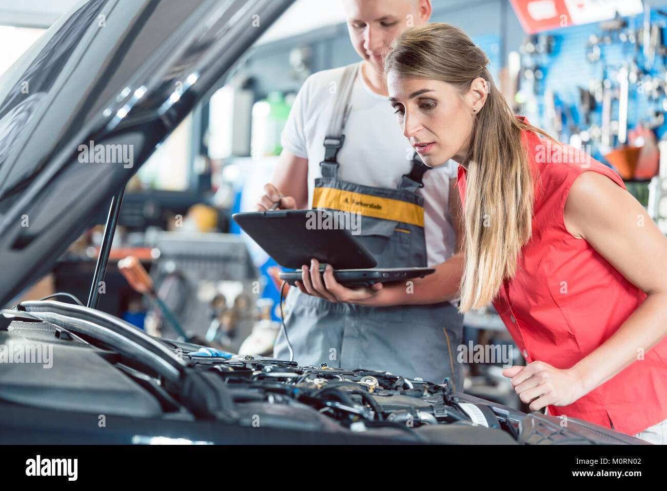 Auto mechanic showing to a customer the engine error codes scann Stock ...