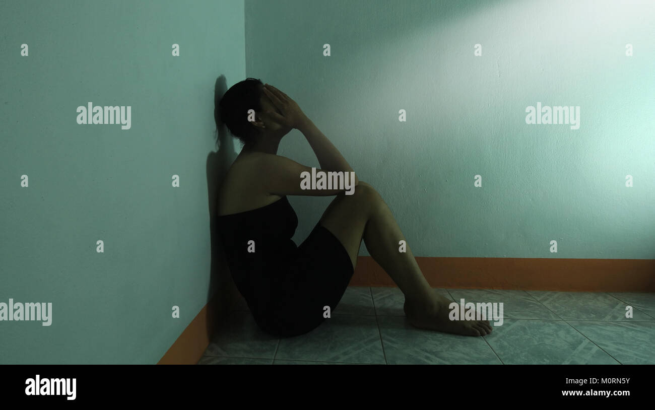 sad woman sitting alone in a empty room Stock Photo - Alamy