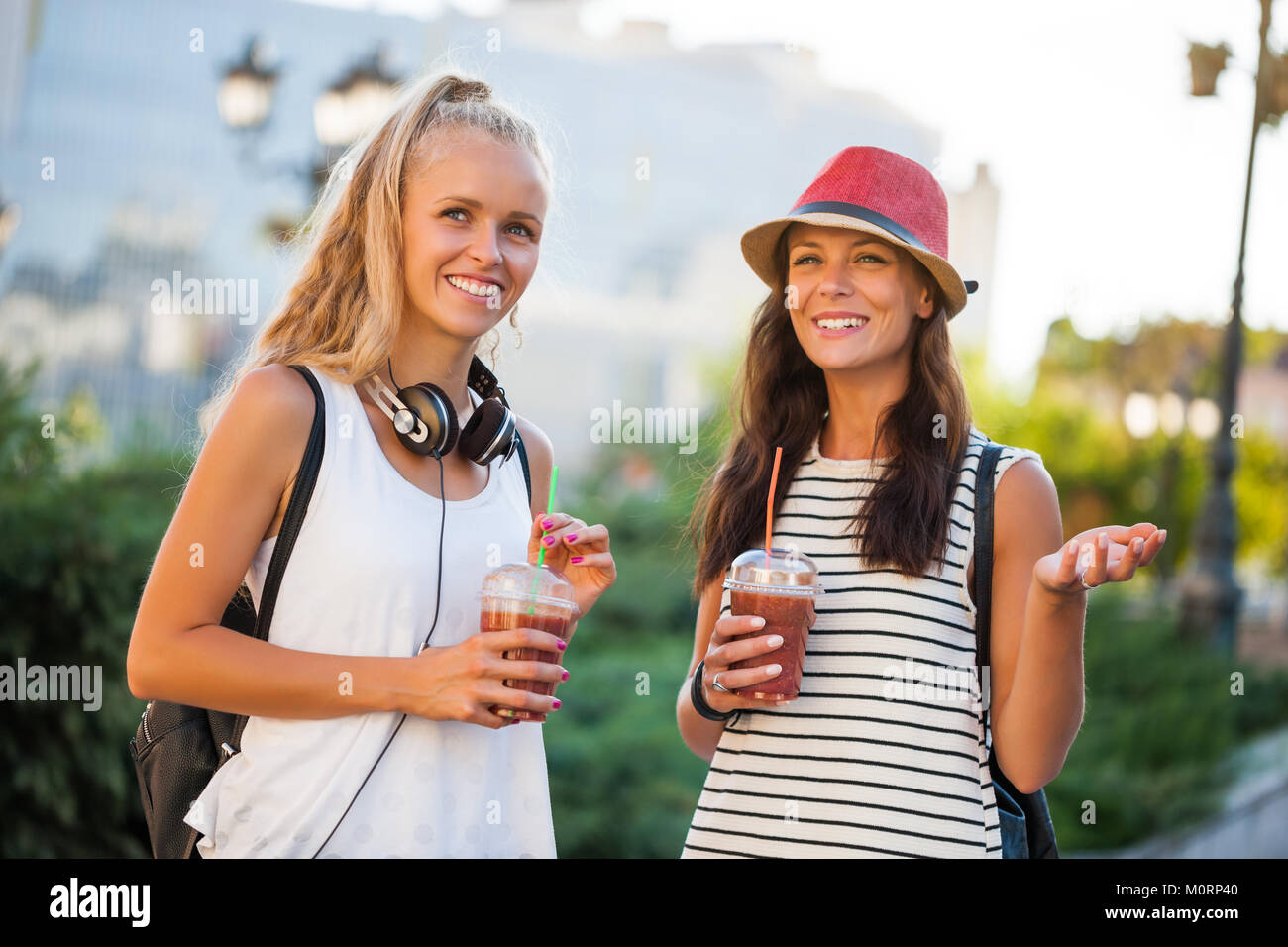 Two happy women are having nice time together in the city. They are ...