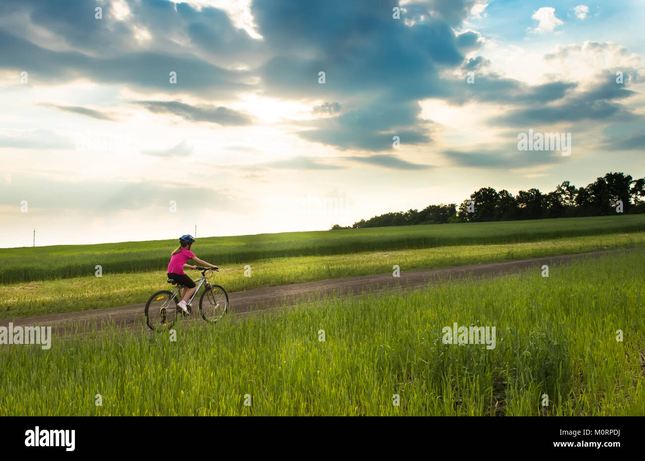 girl on a bicycle in rural landscape Stock Photo - Alamy