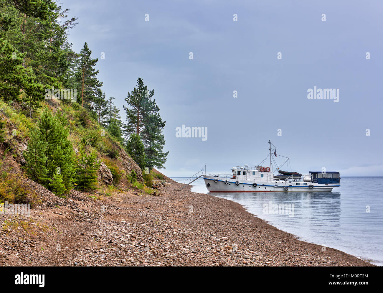 Pleasure boat stands at shore of Lake Baikal. Overcast. Irkutsk region ...