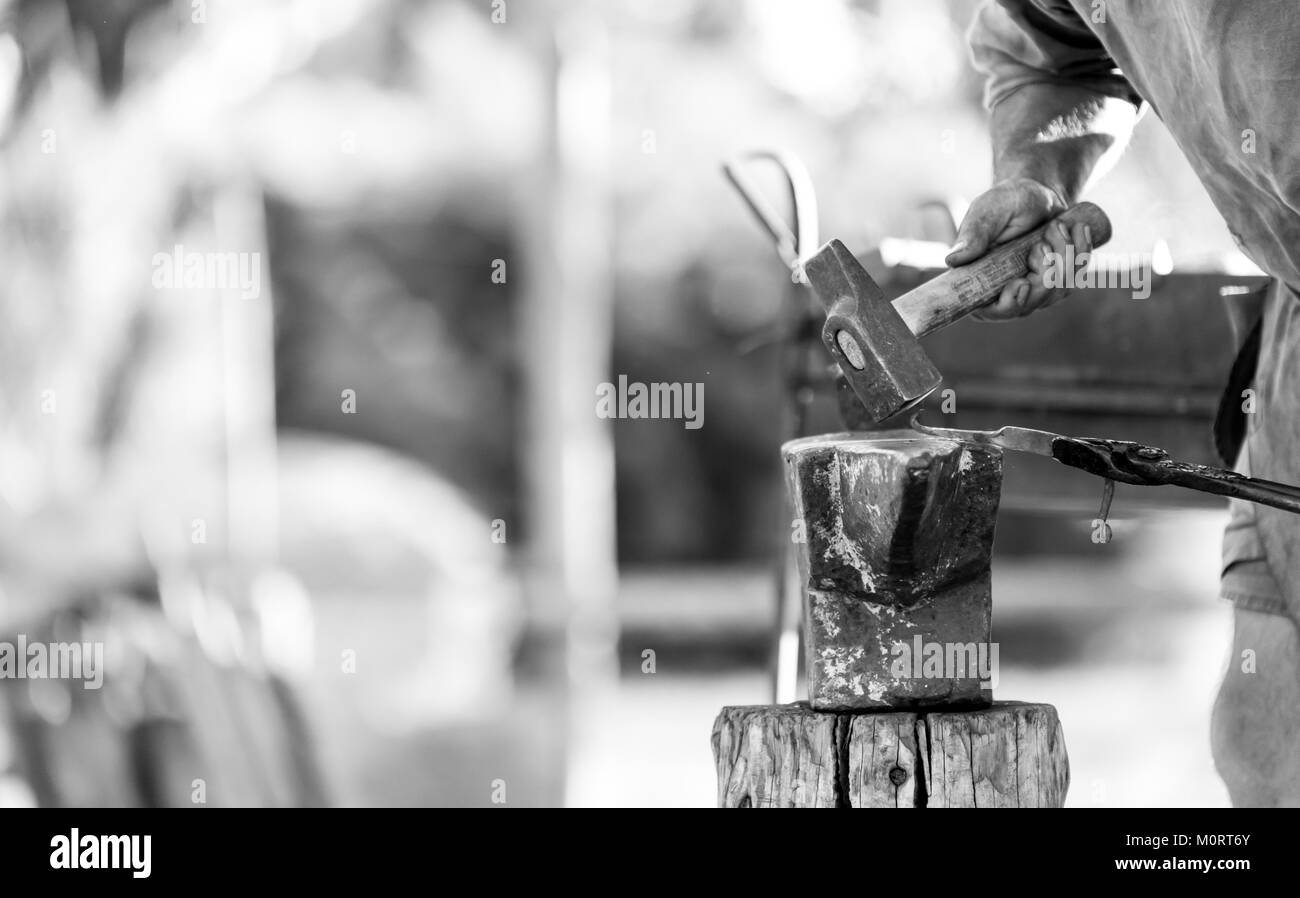 Man working the iron with anvil and hammer Stock Photo - Alamy