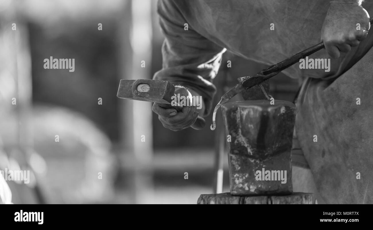 Man working the iron with anvil and hammer Stock Photo - Alamy
