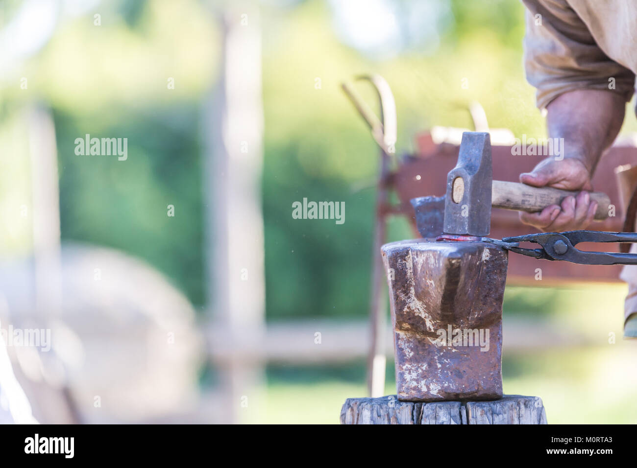 Man working the iron with anvil and hammer Stock Photo - Alamy
