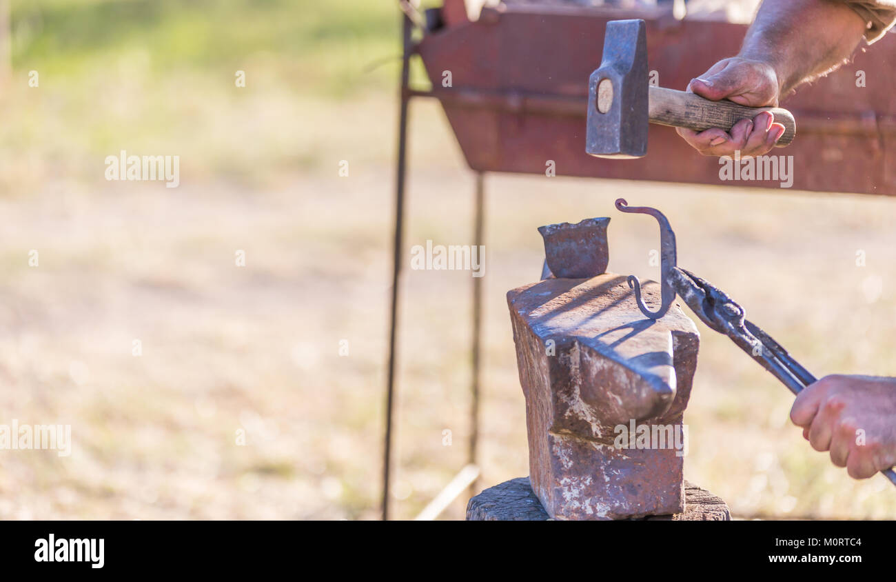 Man working the iron with anvil and hammer Stock Photo - Alamy