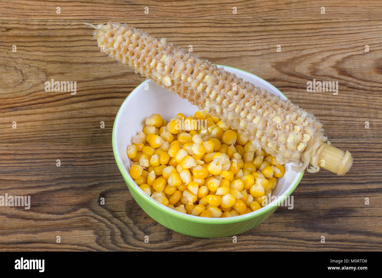 Boiled maize and empty corncob. Yellow corn grains in round bowl and ...