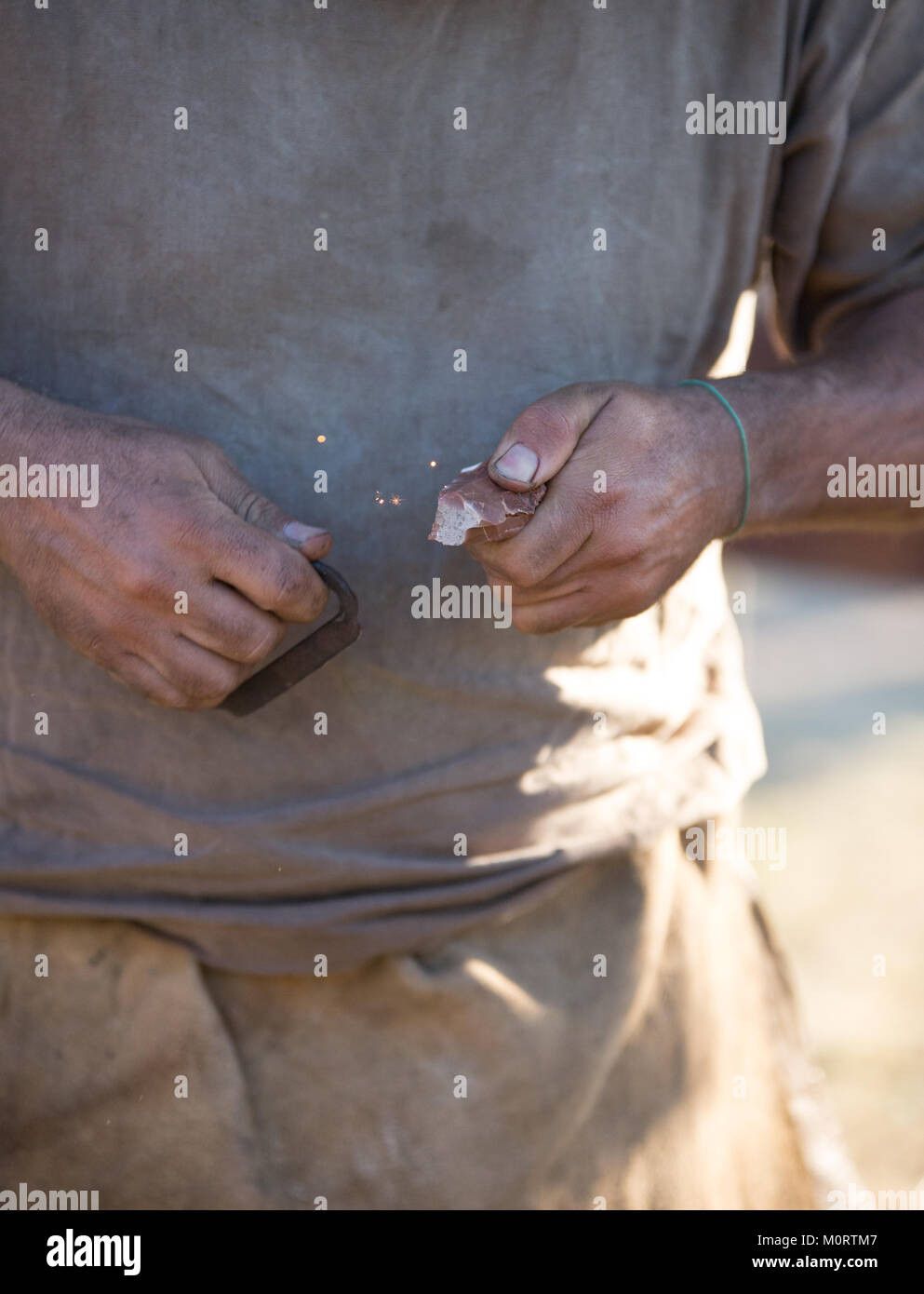Man who creates sparks using a flint and an iron object Stock Photo - Alamy