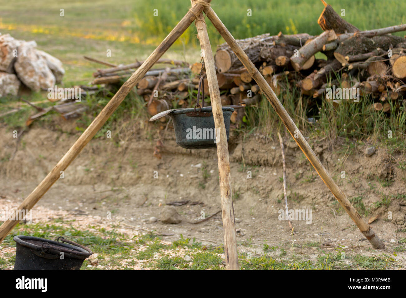 Beautifull Ancient copper pot tied to logs to cook food Stock Photo - Alamy