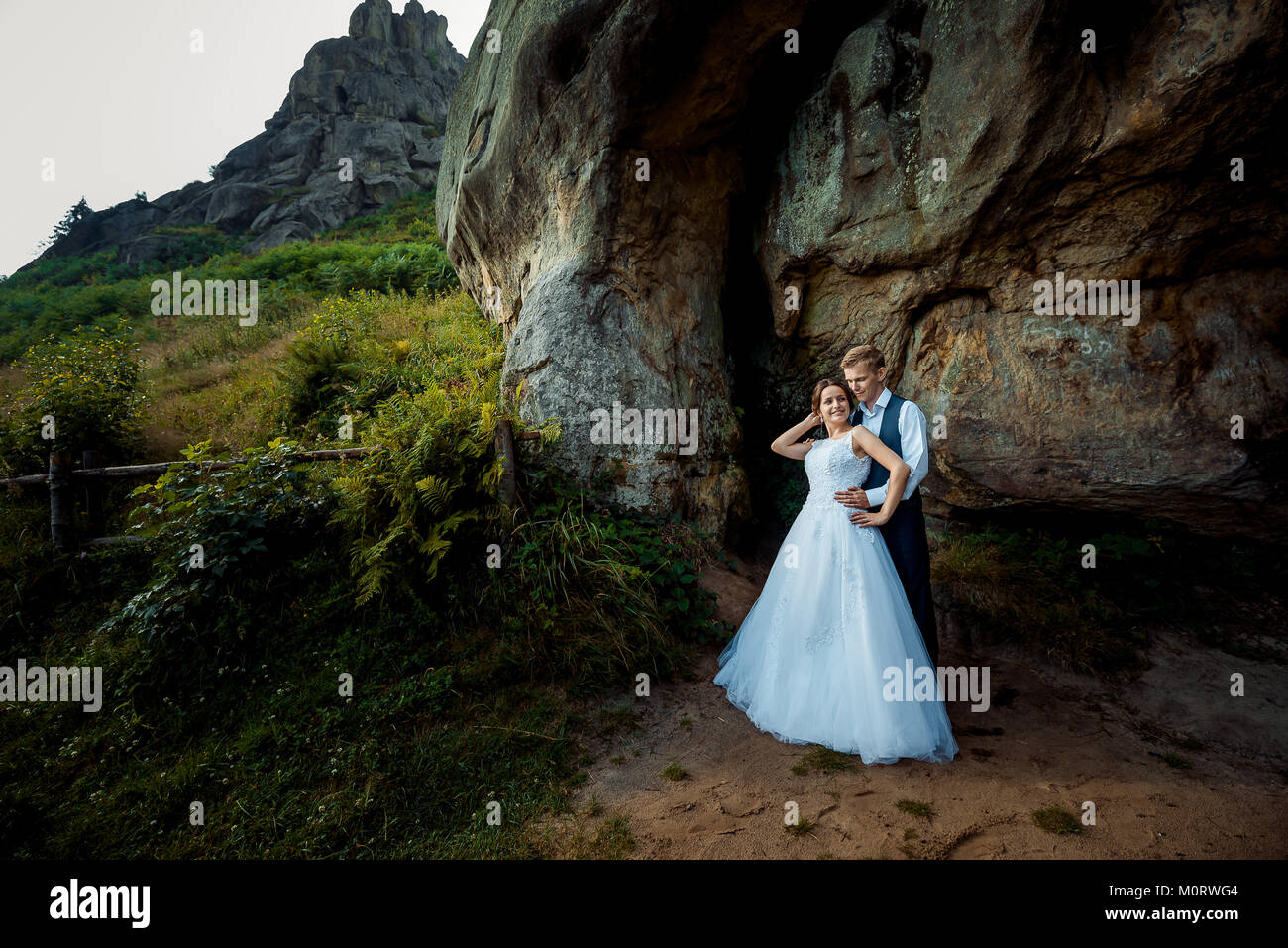 Happy beautiful newlywed couple. Smiling groom hugging the charming ...