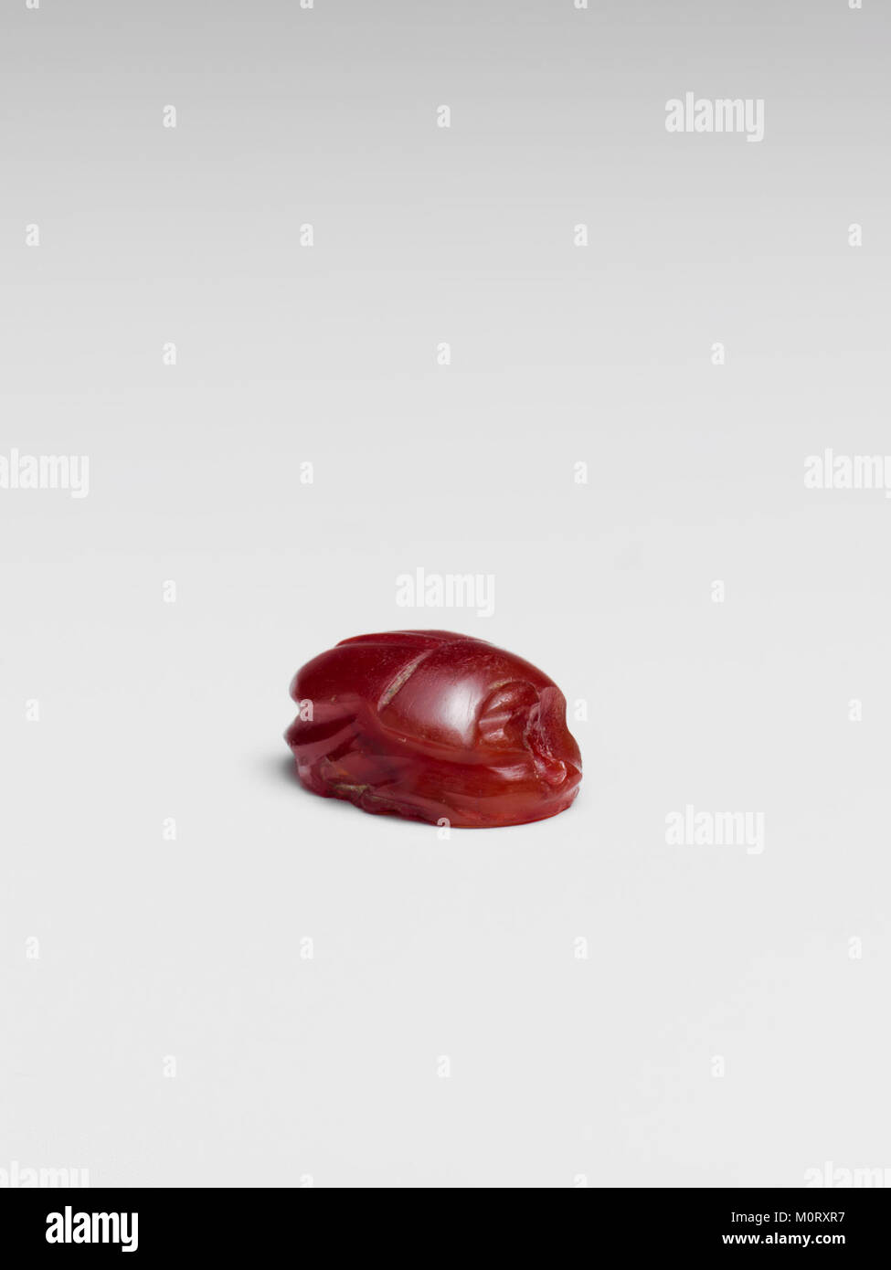 A carnelian scarab, a type of ancient Egyptian artifact, held in the ...