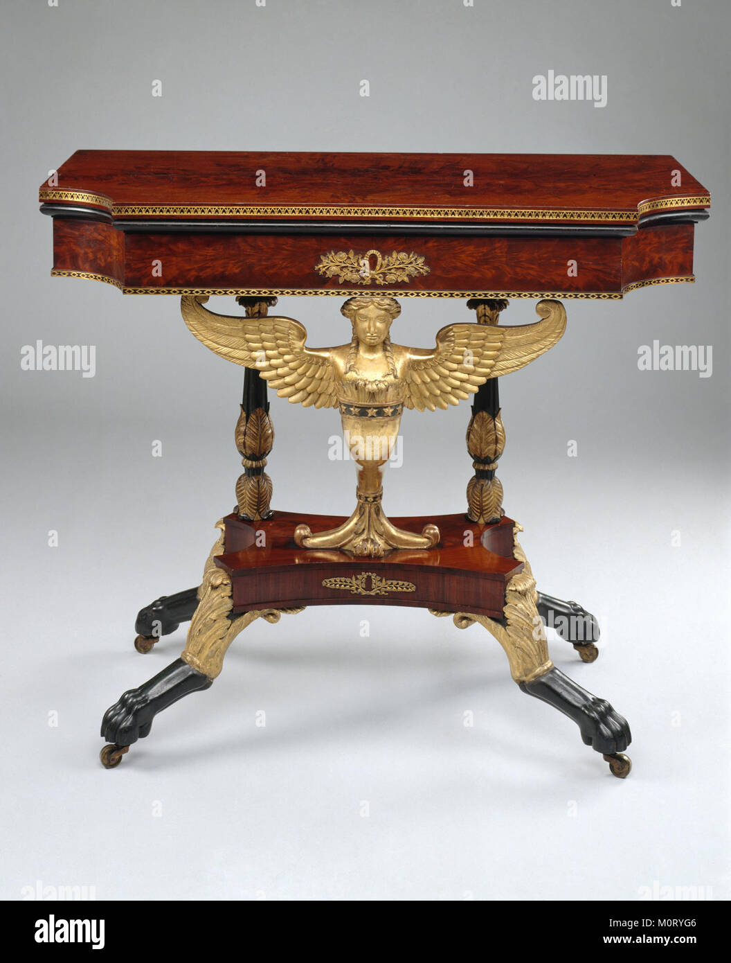 This image shows a historical card table, crafted with intricate design ...