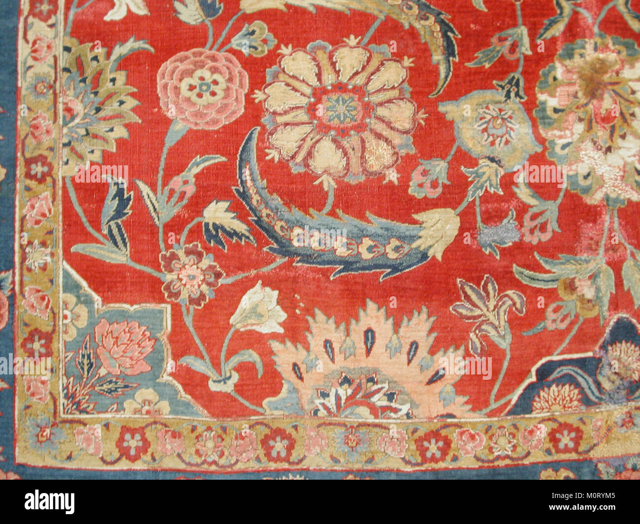A carpet featuring intricate scrolling vines and blossoms, part of The ...