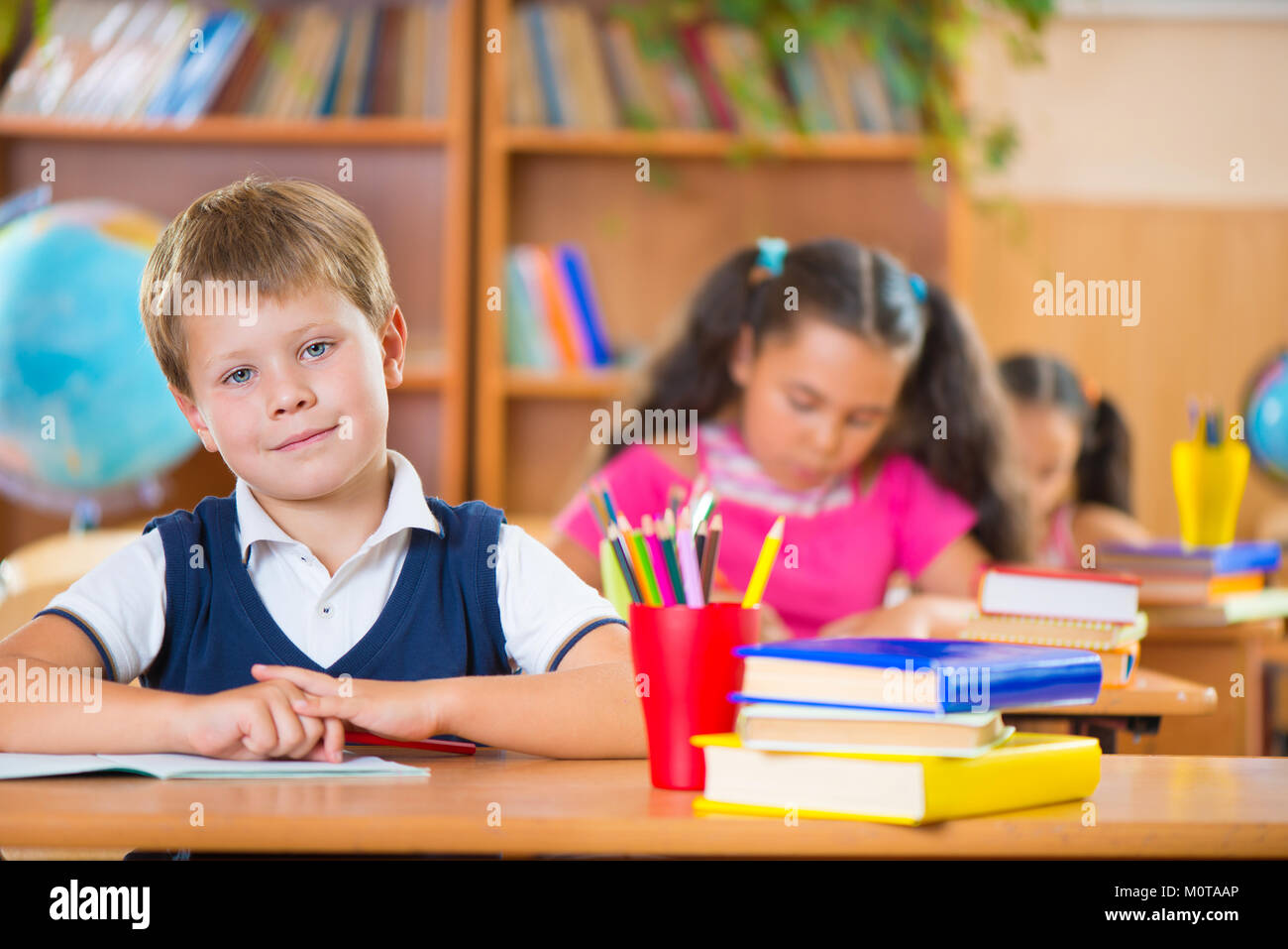 Happy elementary students in classroom at school Stock Photo - Alamy