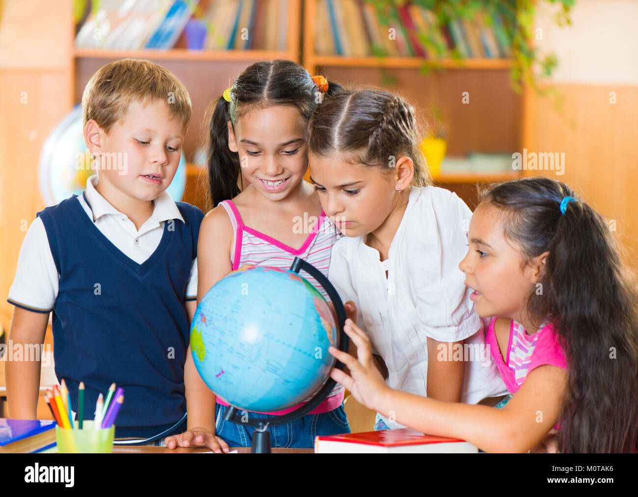 Happy elementary students in classroom at school Stock Photo - Alamy