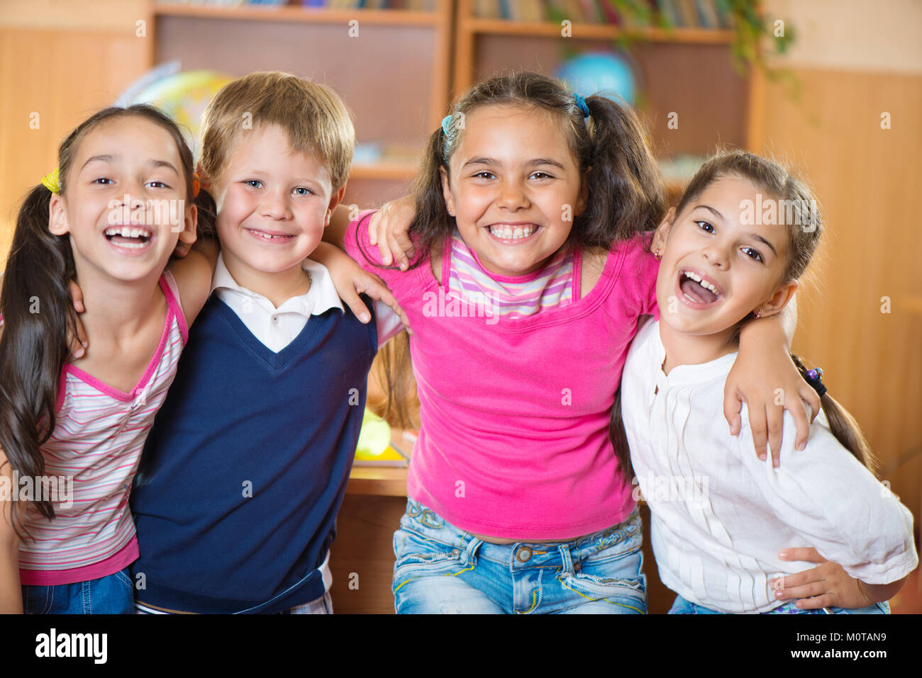 Happy elementary students in classroom at school Stock Photo - Alamy
