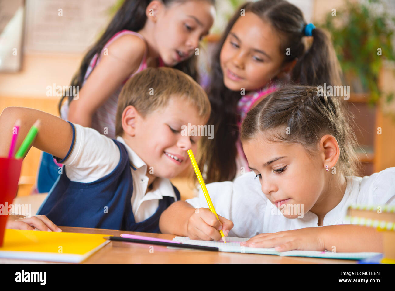 Happy elementary students in classroom at school Stock Photo - Alamy