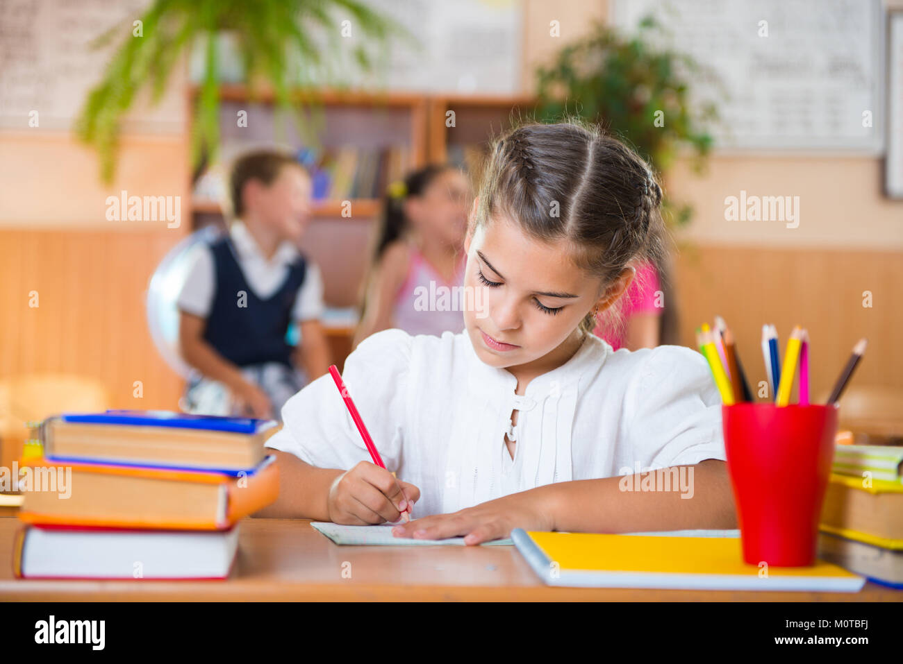 Happy elementary students in classroom at school Stock Photo - Alamy