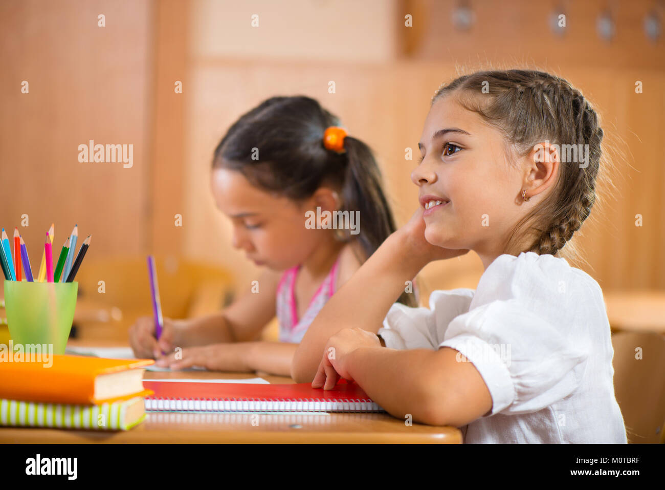 Two happy smiling girls at school during lesson Stock Photo - Alamy