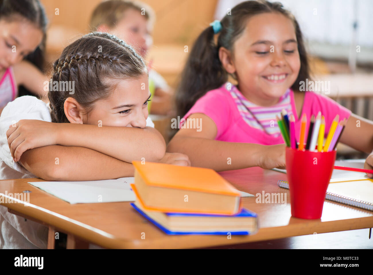 Happy elementary students in classroom at school Stock Photo - Alamy