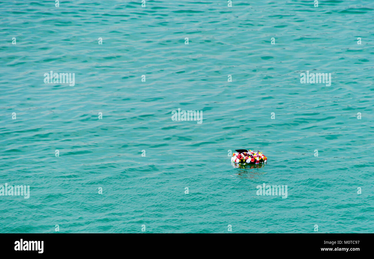 A wreath of flowers is dropped into the sea during a ceremony during ...