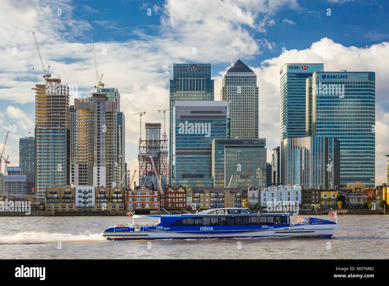 MBNA high speed catamaran on Thames heading past modern skyscrapers of ...